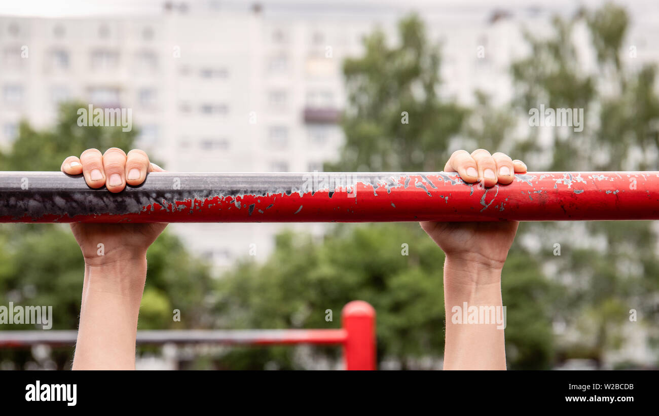 Hanging from the gymnastic bar, hands on bar. Playground, sports and a ...