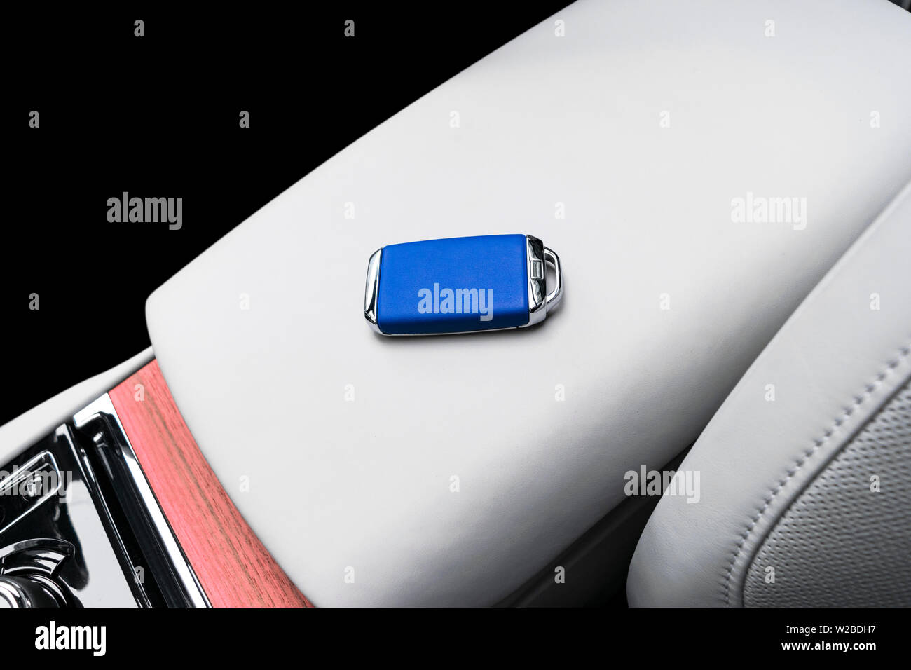 Closeup inside vehicle of wireless blue leather key ignition on natural ...