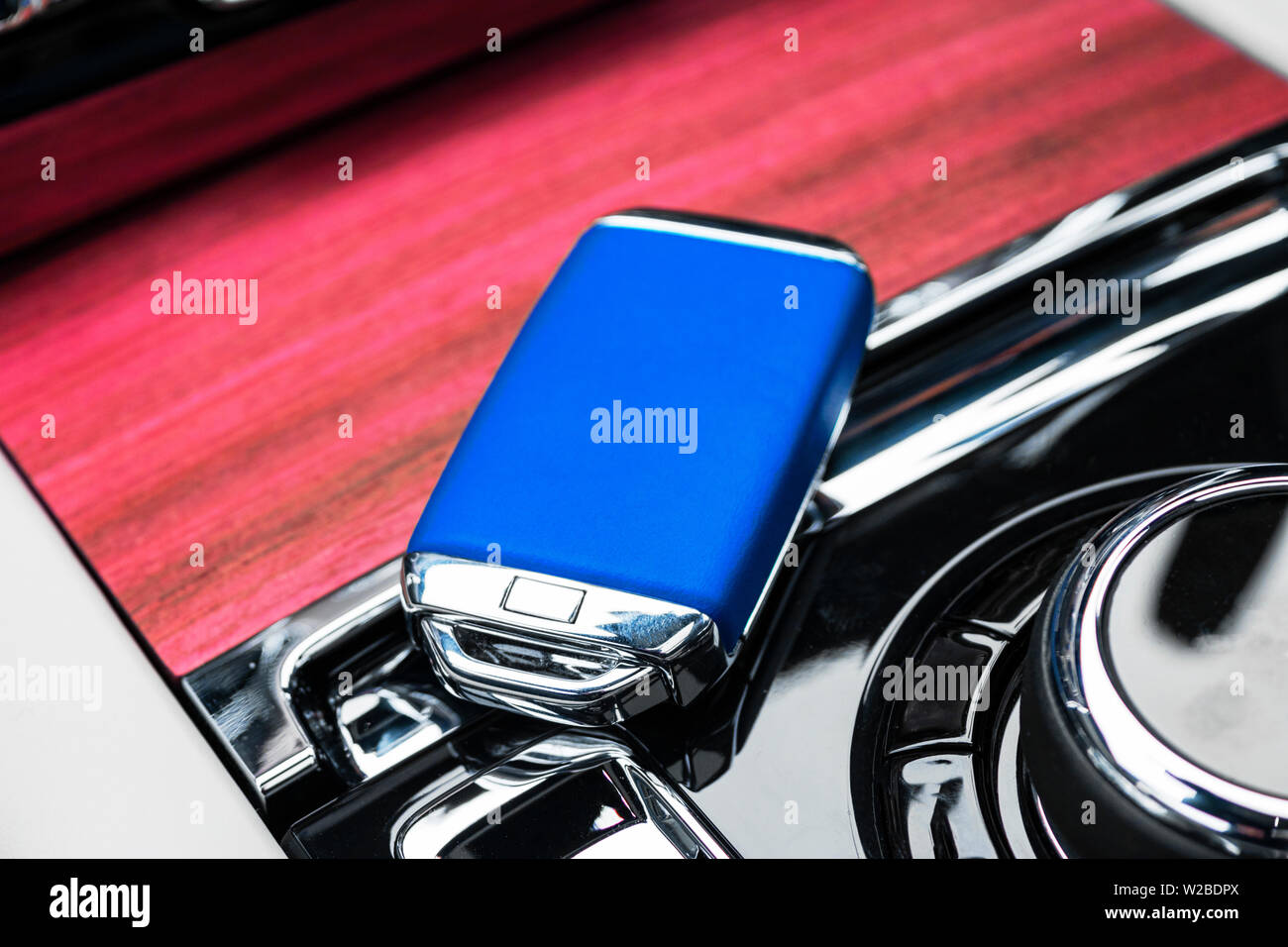 Closeup inside vehicle of wireless blue leather key ignition on natural ...