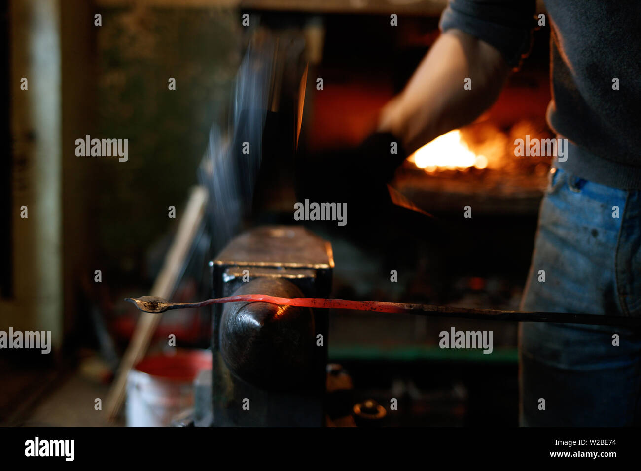 Blacksmith forging red-hot metal with hammer Stock Photo - Alamy