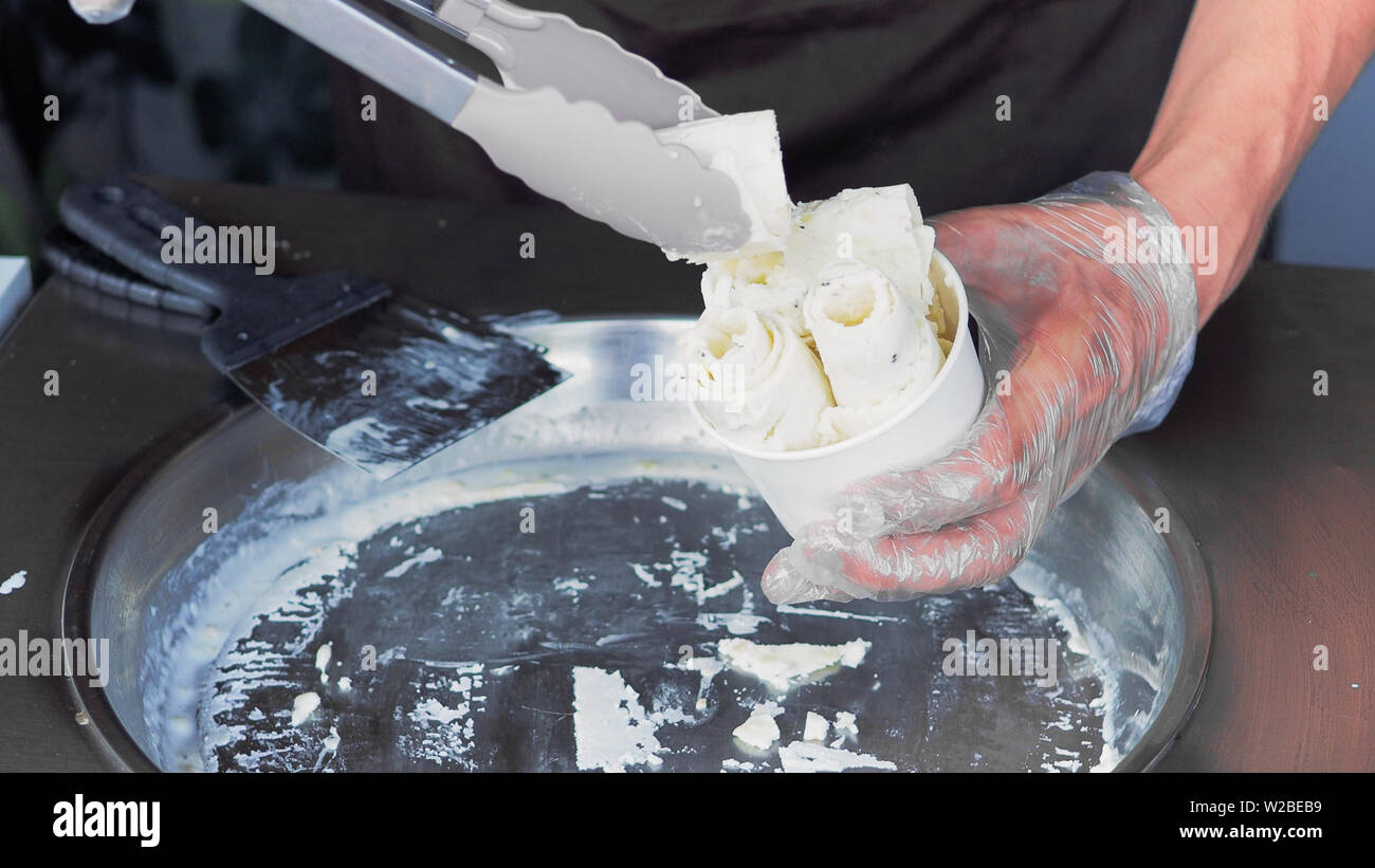 Stir-fried ice cream rolls at freeze pan. Making rolled ice cream, hand ...