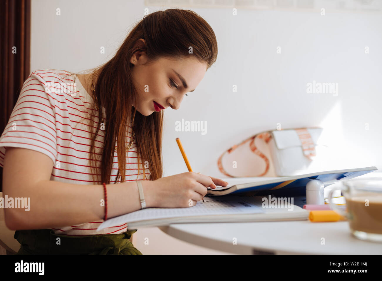Enjoy your study. Cute student keeping smile on her face while ...