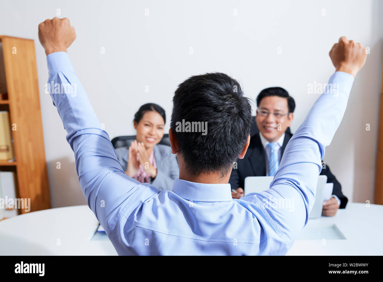 Happy excited young man standing in front of human resources managers ...