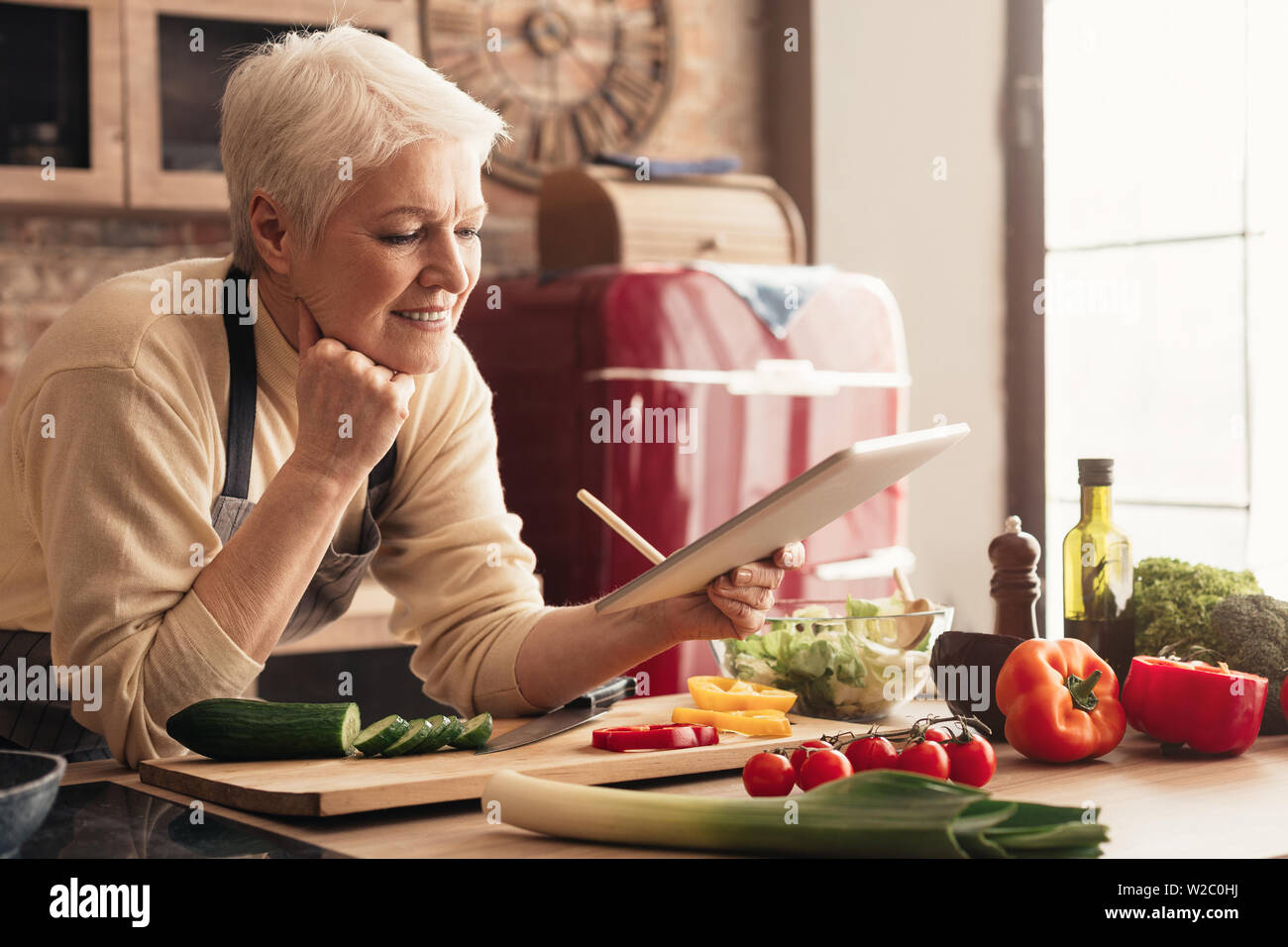 Senior woman cooking tablet hi-res stock photography and images - Alamy