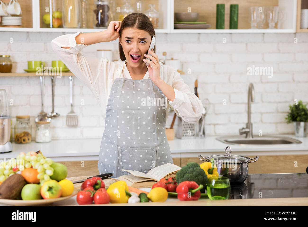 How to cook? Shocked woman talking on phone Stock Photo - Alamy