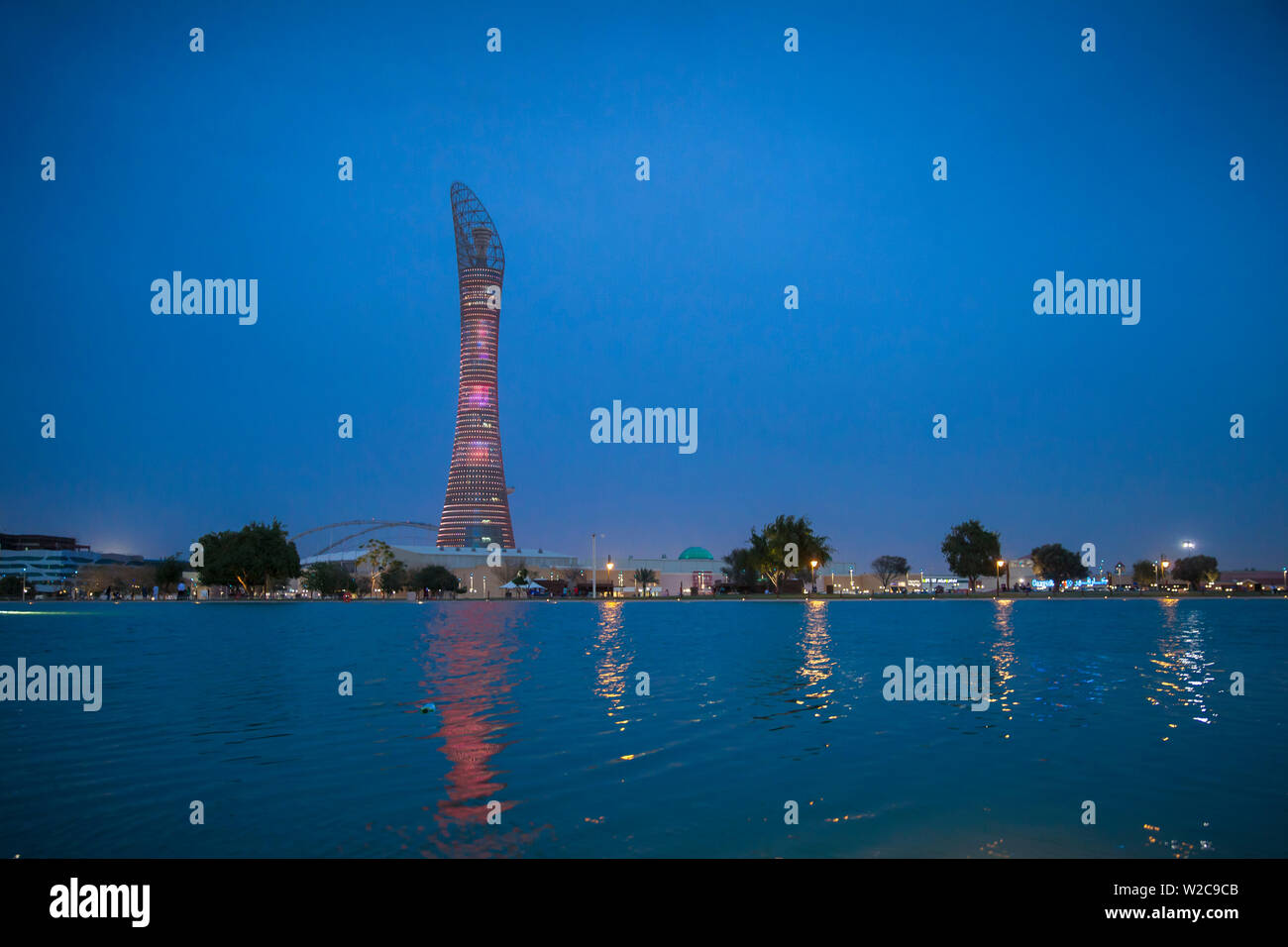 Qatar, Doha, The Torch Hotel reflecting in the lake in Aspire Park ...