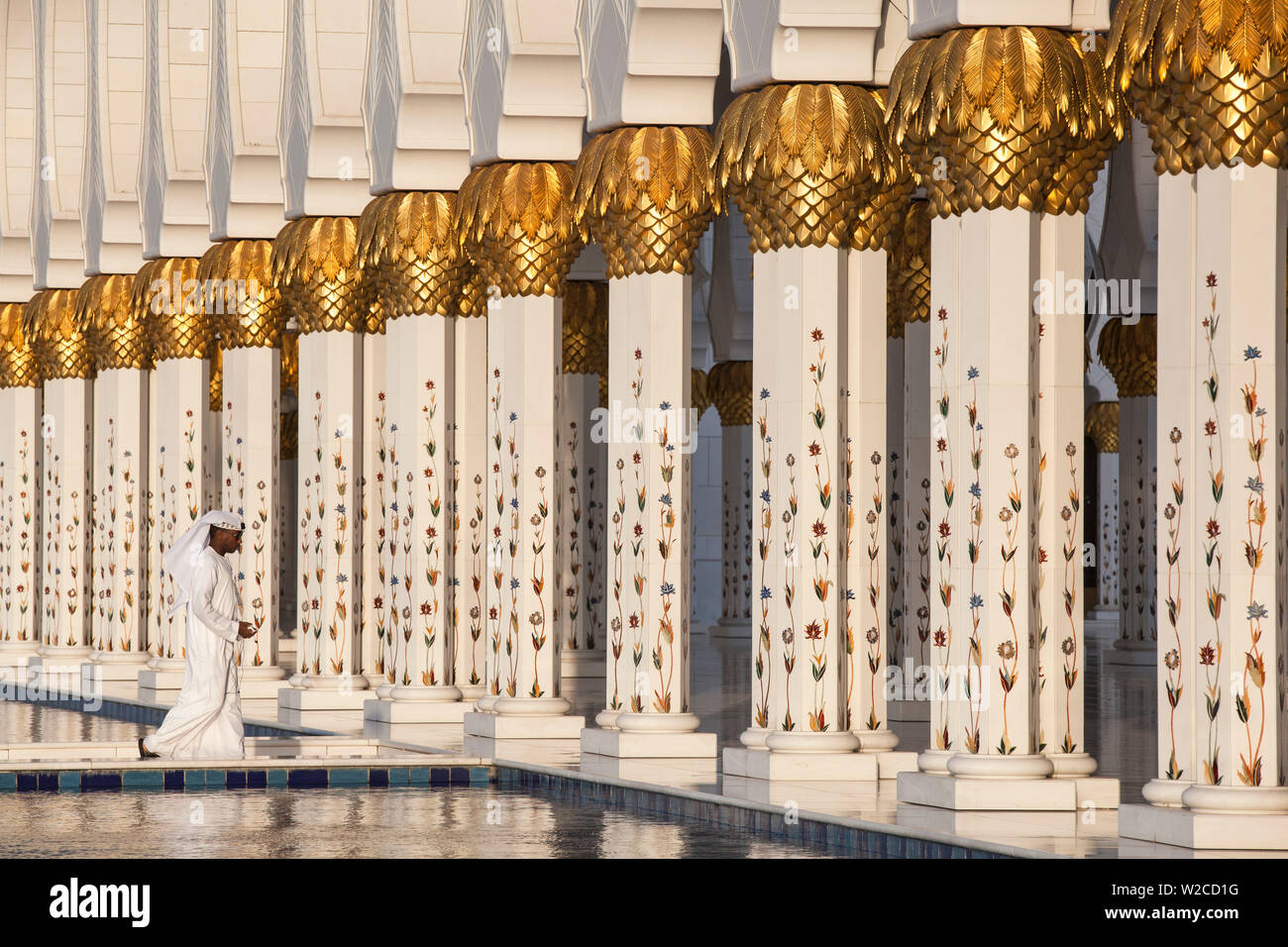 United Arab Emirates, Abu Dhabi, Man approaches gilded columns at ...