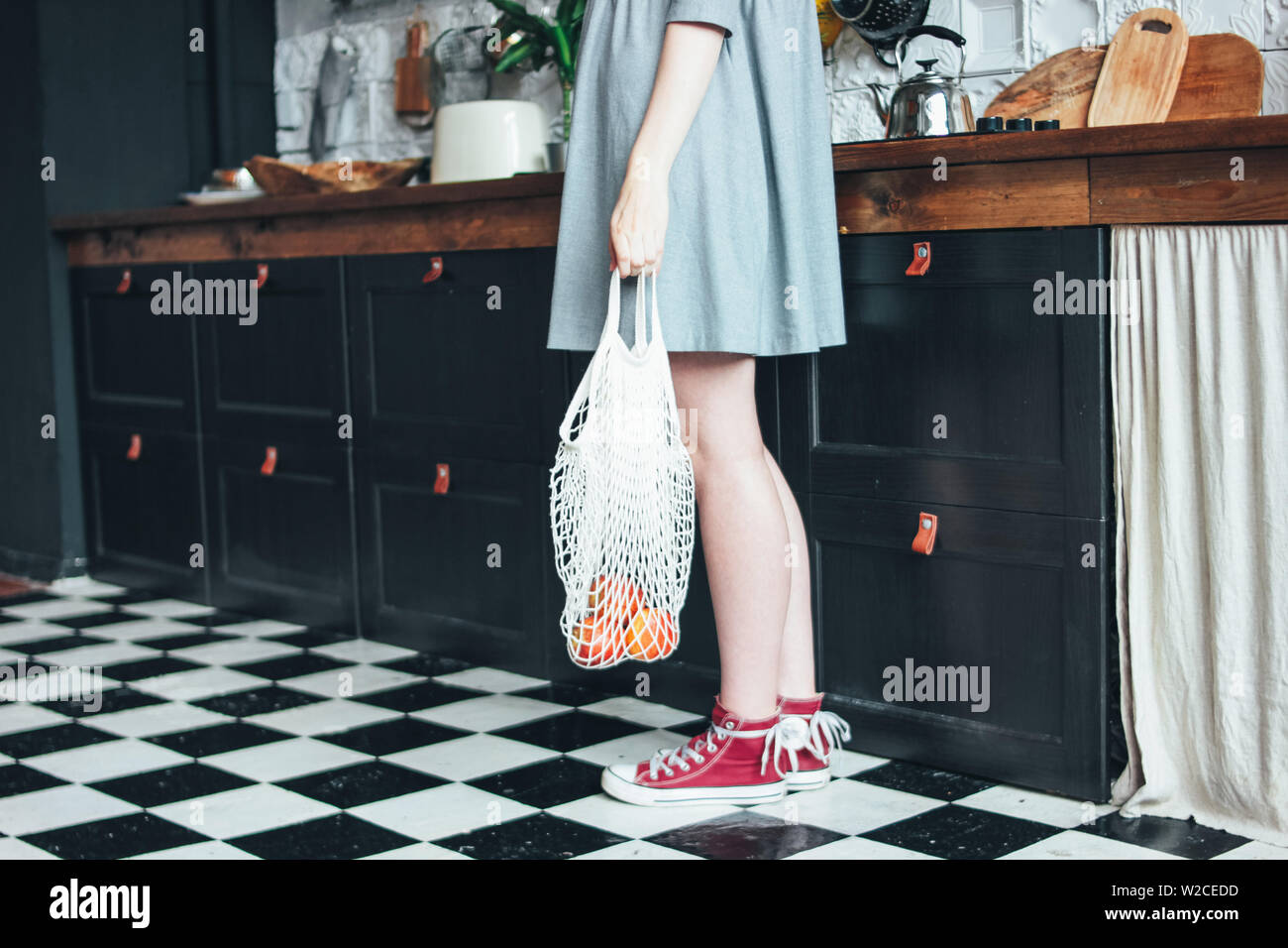 Young woman in grey dress with knitted rag bag string bag shopper in ...