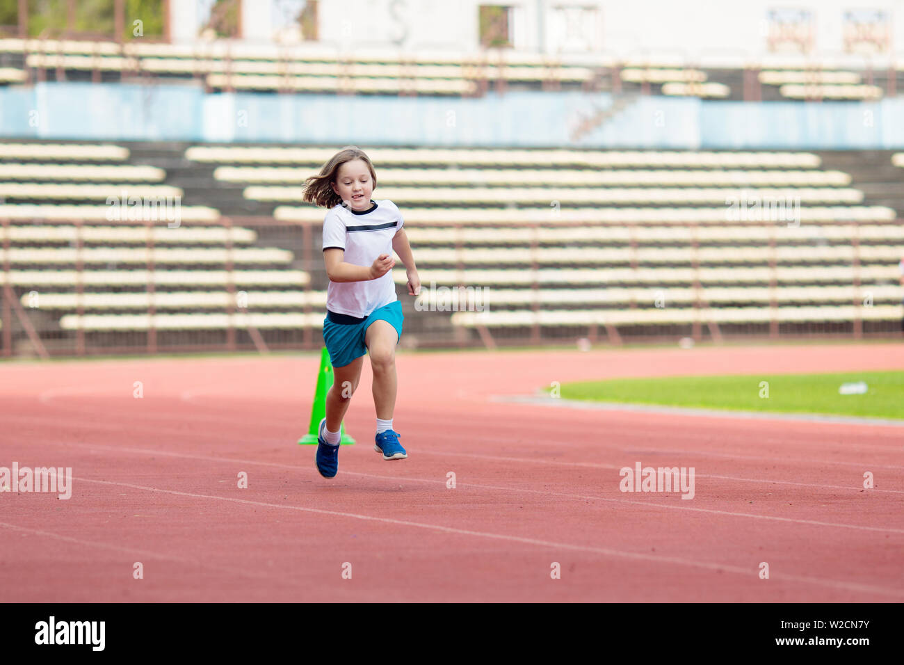 Child running in stadium. Kids run on outdoor track. Healthy sport ...