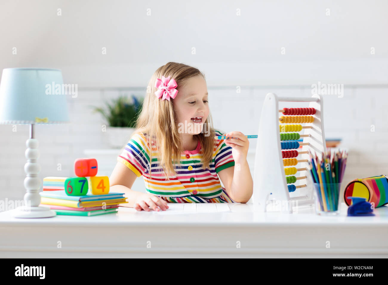 Child doing homework at home. Little girl with wooden colorful abacus ...