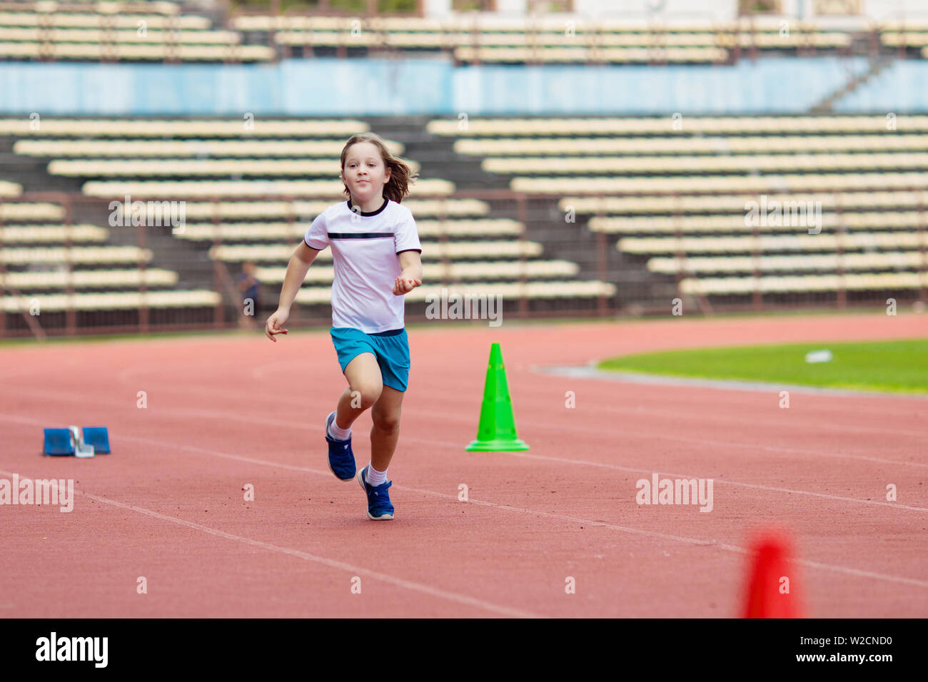 Child running in stadium. Kids run on outdoor track. Healthy sport ...