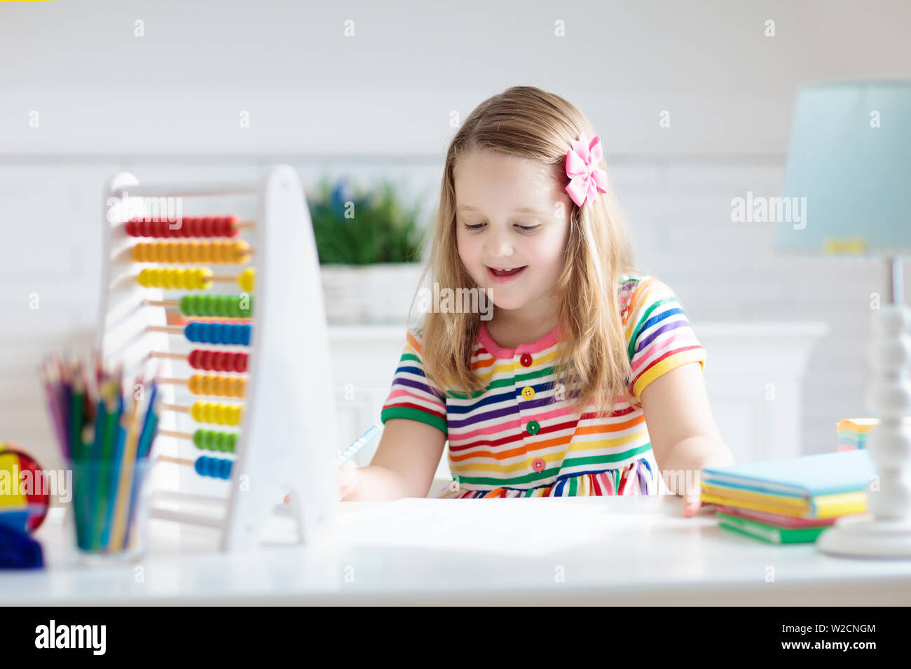 Child doing homework at home. Little girl with wooden colorful abacus ...