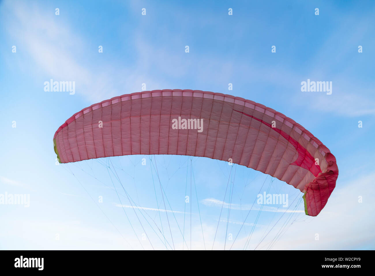 Pink dome of paraglider flying in blue bright sky Stock Photo - Alamy