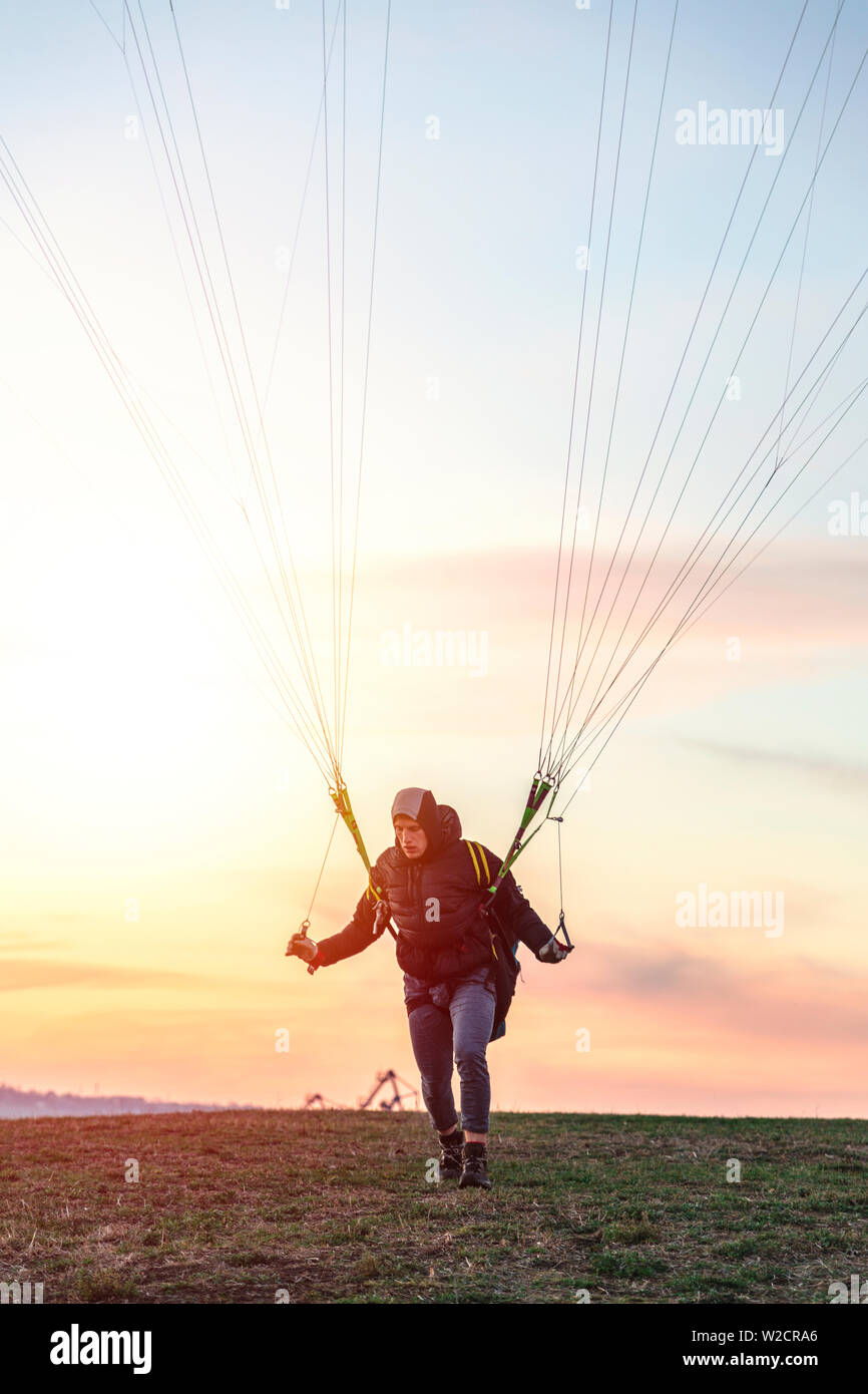 Man with paraglider getting ready to fly in sky Stock Photo - Alamy