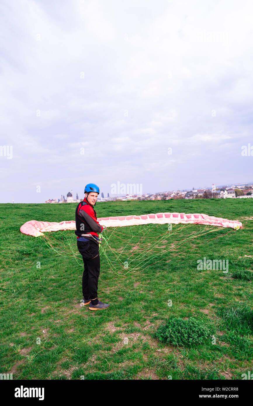 Man landed and folds parachute lying on ground Stock Photo - Alamy