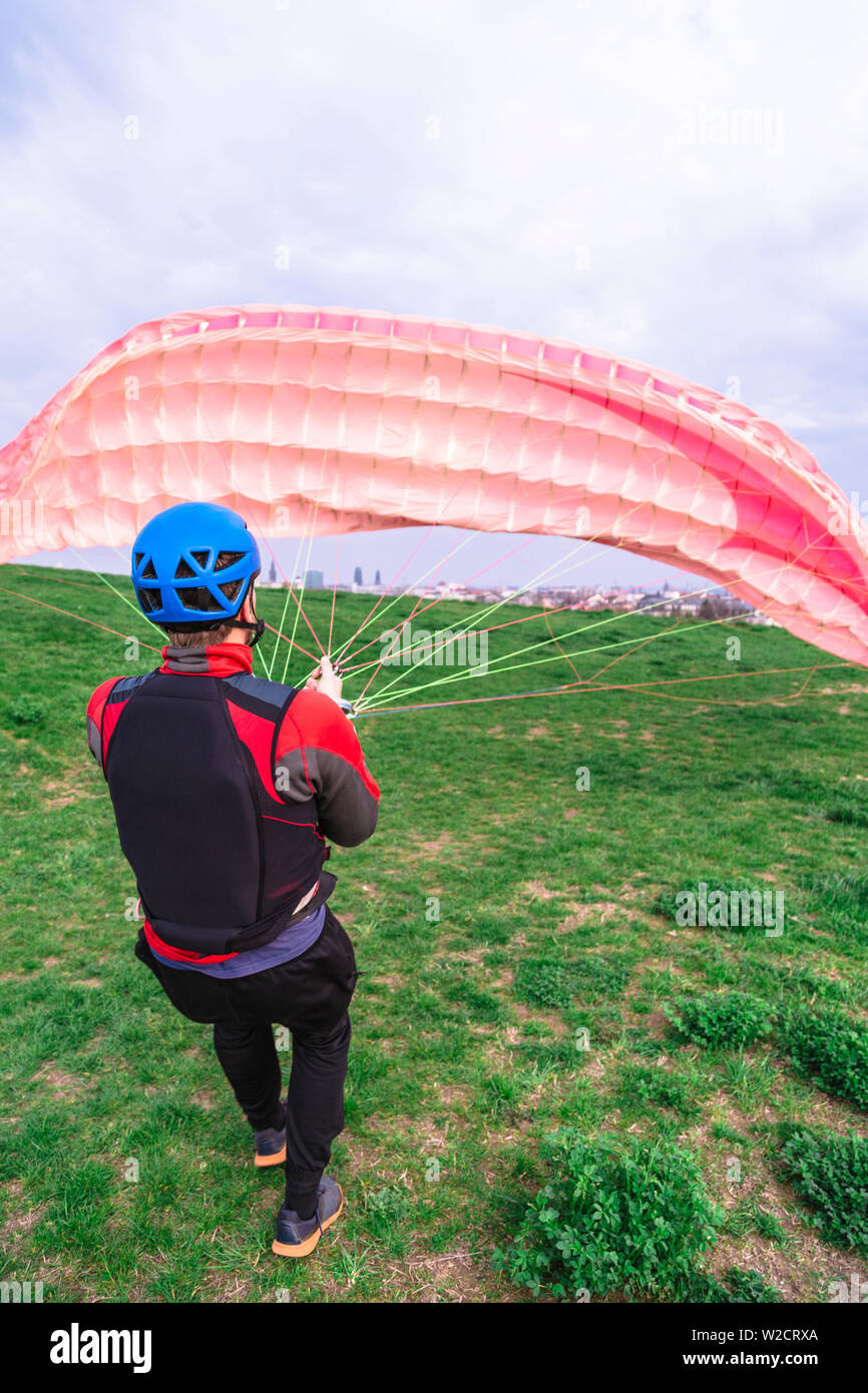 Man with paraplane starting to fly from hill top Stock Photo - Alamy