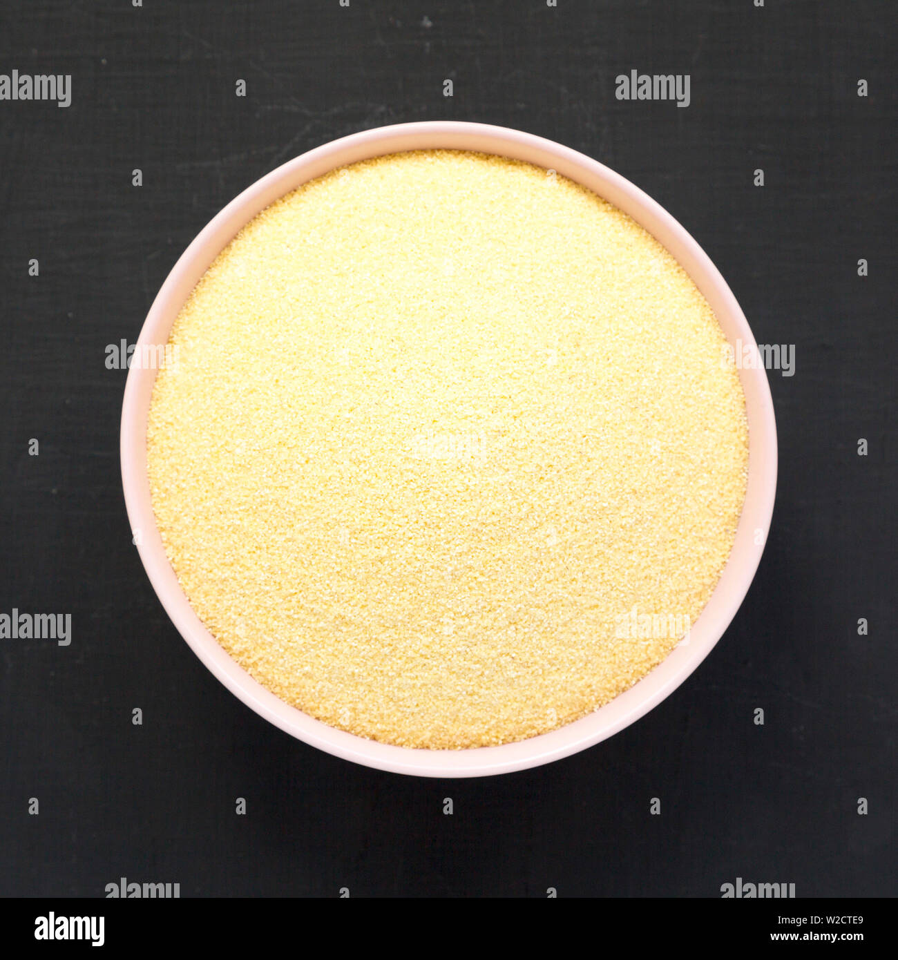 Overhead view, dry semolina durum flour in a pink bowl over black ...