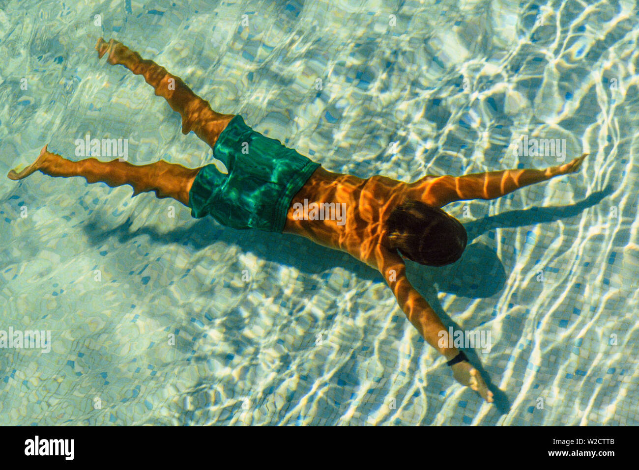 Corsica, France. August 1990. A boy swimming underwater in a swimming ...