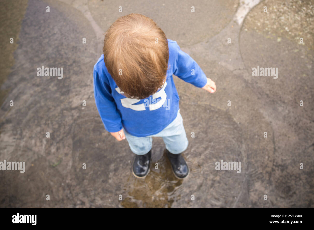 Kid child jumping puddle water splash hi-res stock photography and ...