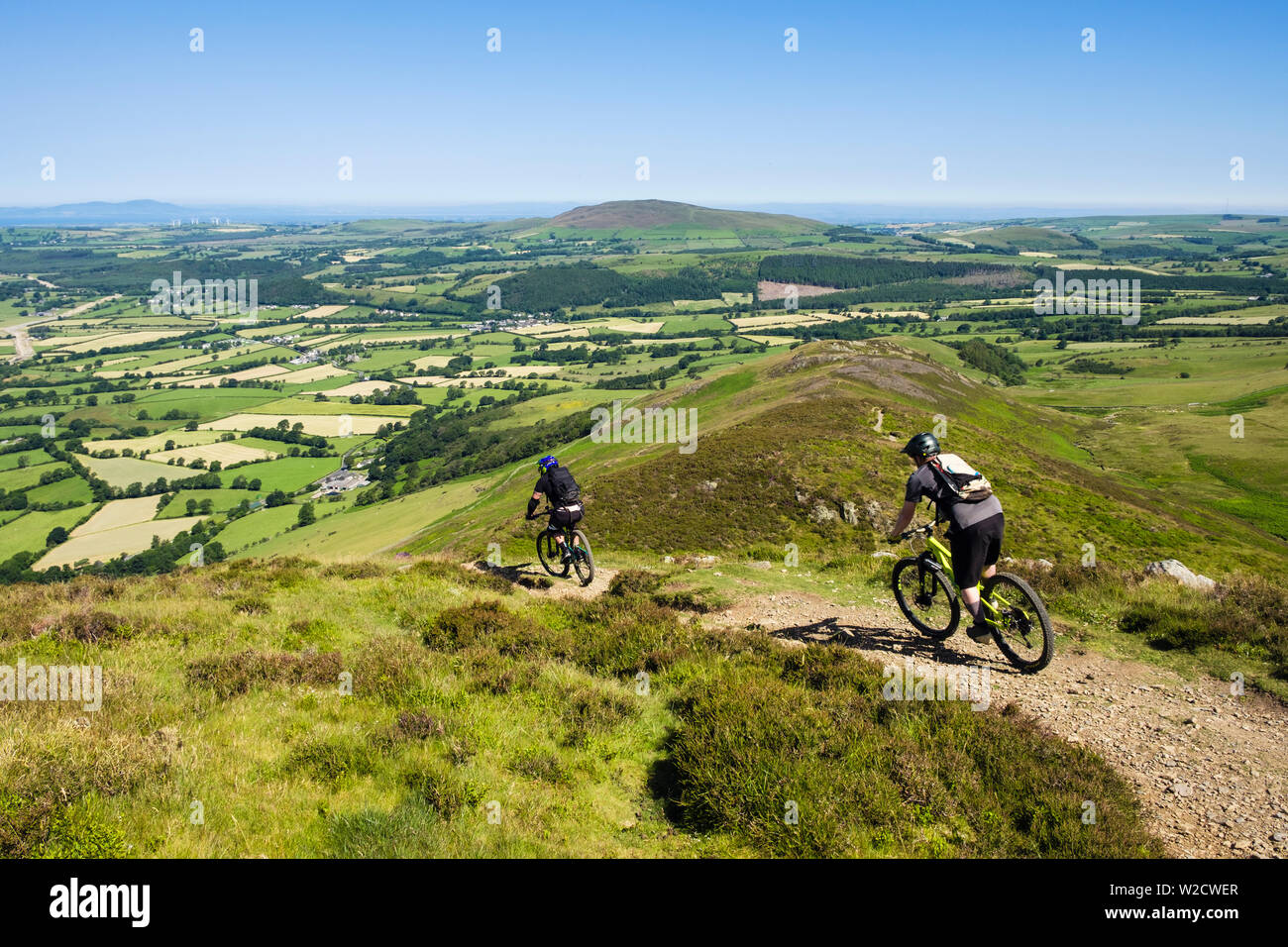 Two male cyclists on mountain bikes biking down a path on Longside Edge ...