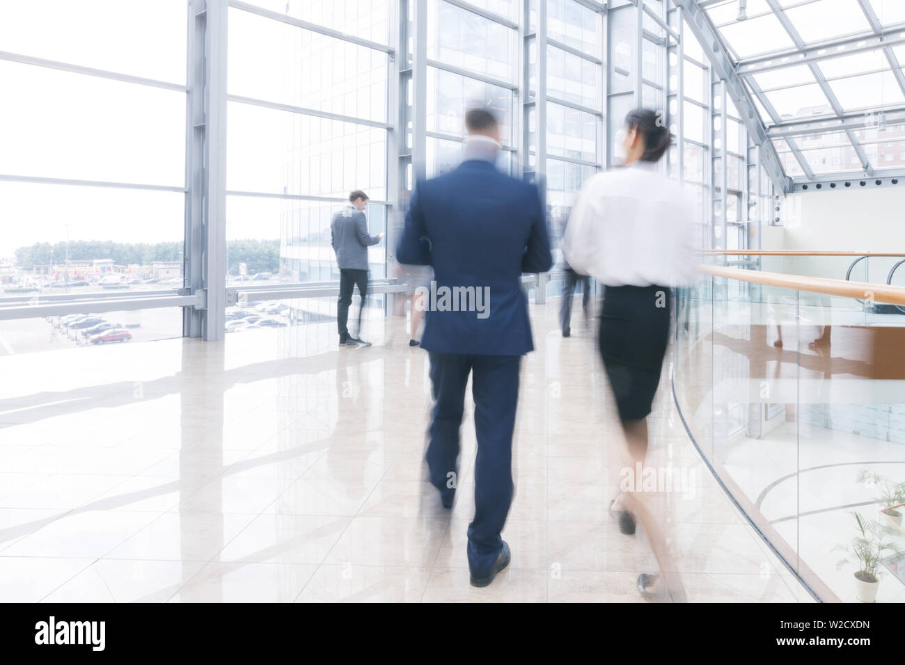 Business people walking in a modern hall of office building Stock Photo ...