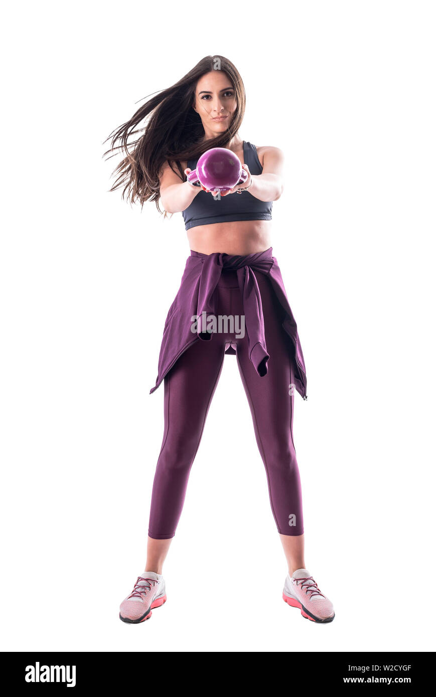 Dynamic shot of kettlebell swing in mid air by fitness attractive woman ...