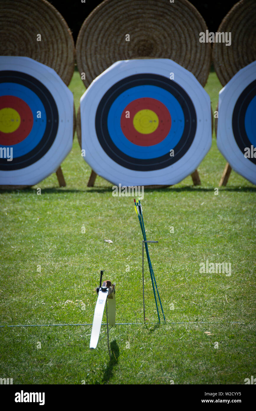 Archery range with bow, arrows and target in a line Stock Photo - Alamy