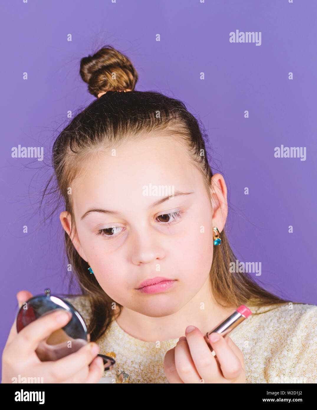 Lipstick for a unique shine. Adorable little girl applying lipstick ...