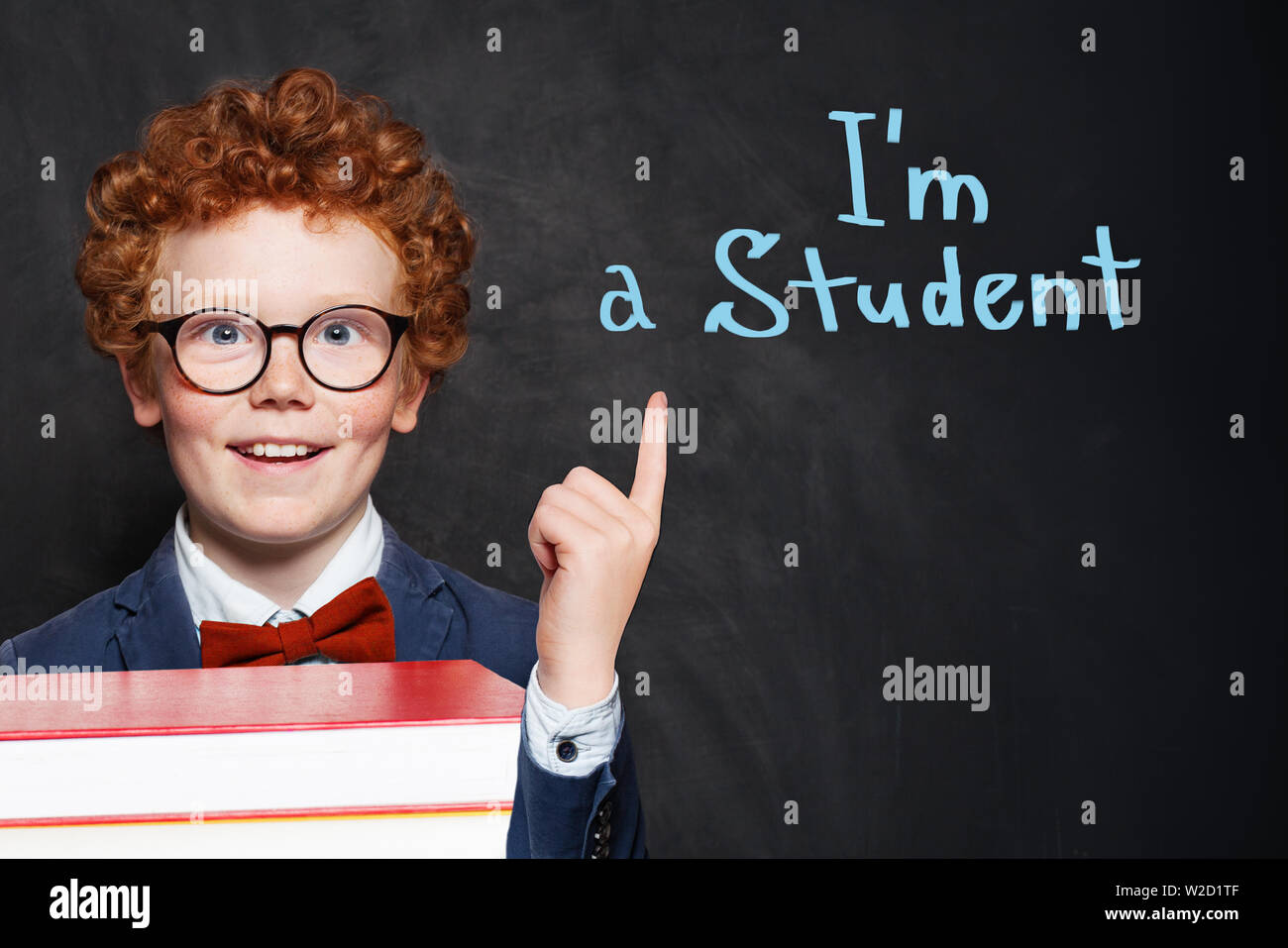 Happy child pointing up on chalkboard background. Back to school ...