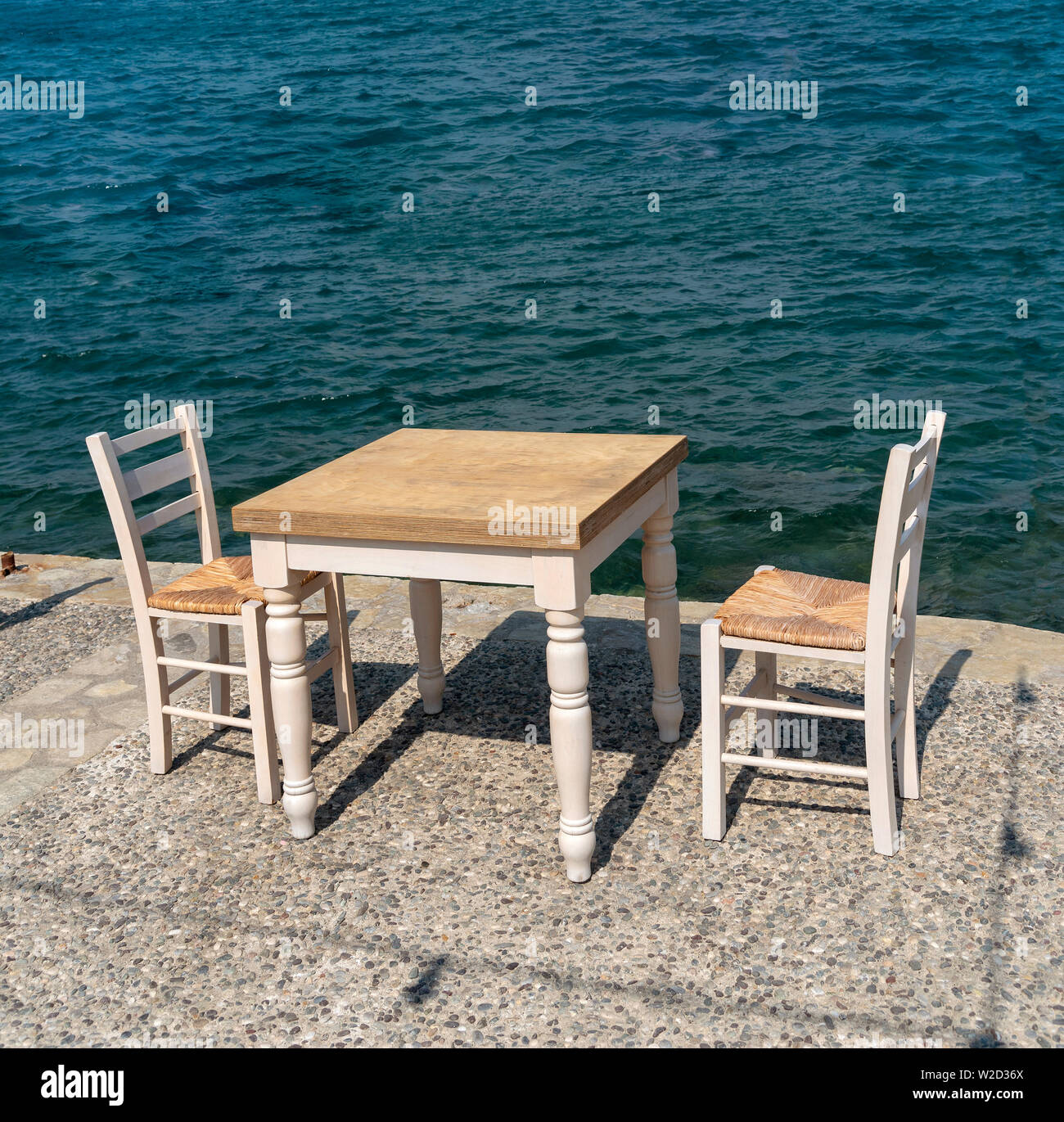 Ierapetra, Crete, Greece. June 2019. Table and two chairs set customer ...