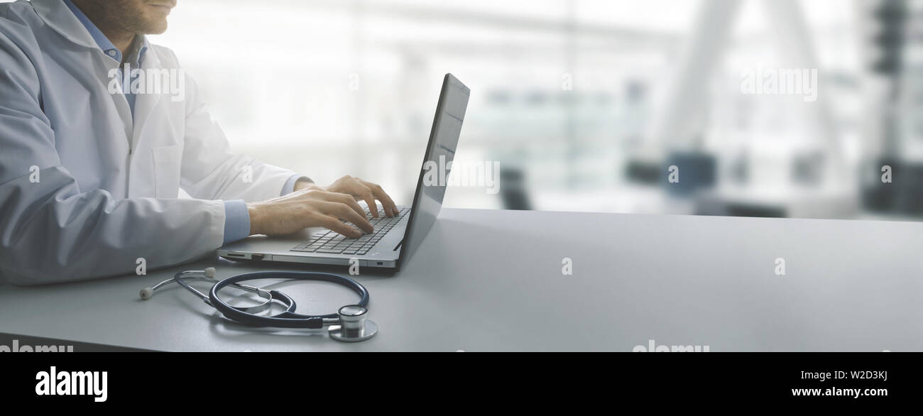 doctor working on laptop computer in modern clinics office. copy space ...