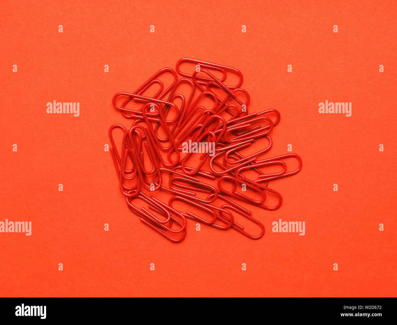 Red paperclips on a red background Stock Photo - Alamy