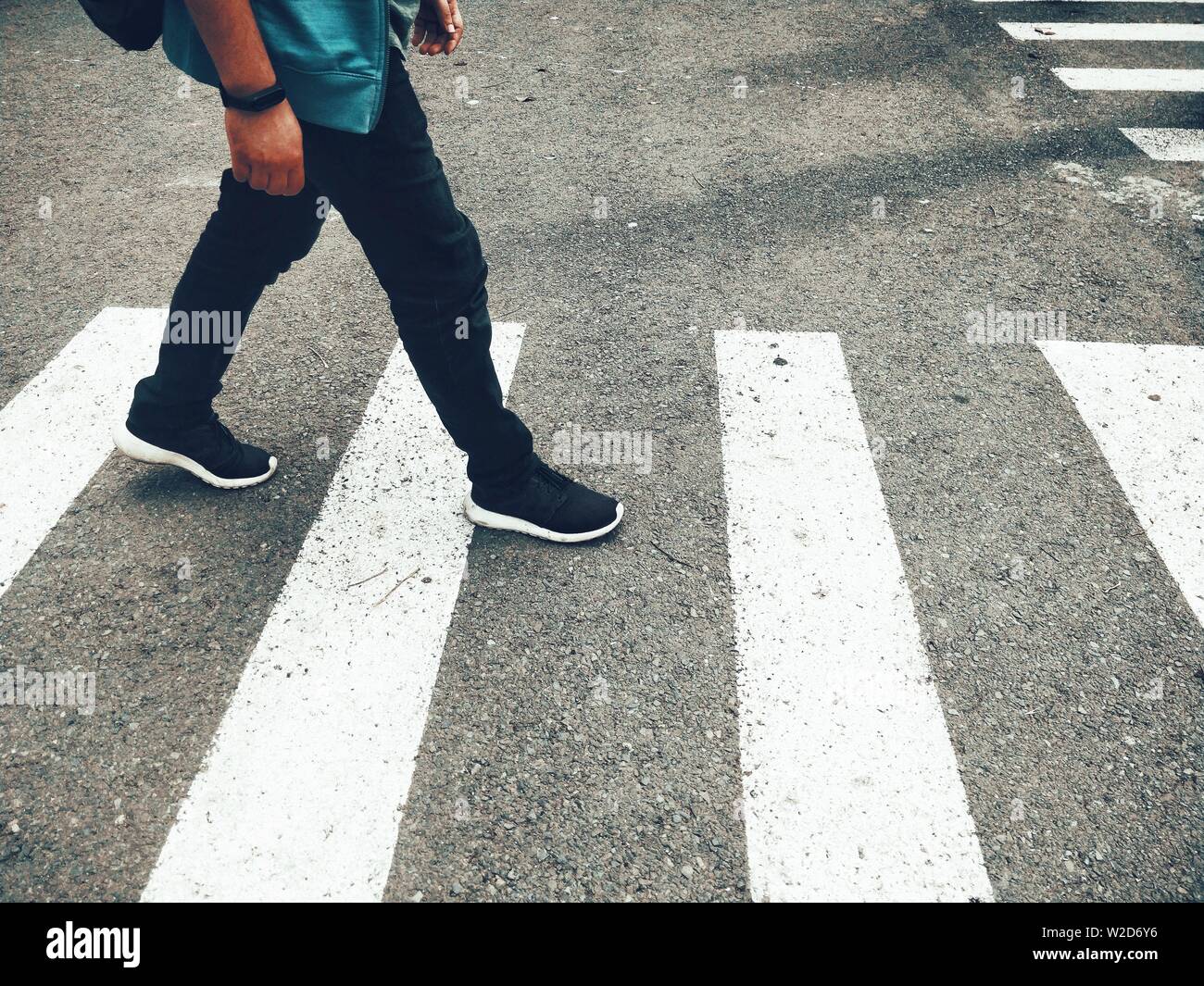 Low section of a pedestrian walking on crosswalk Stock Photo - Alamy