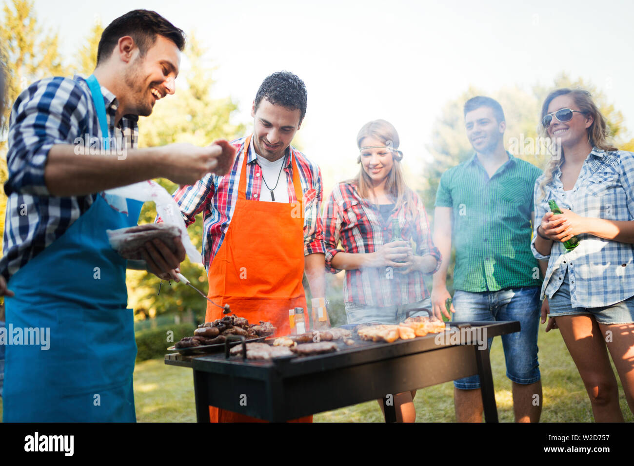 Friends enjoying bbq party and having fun Stock Photo - Alamy