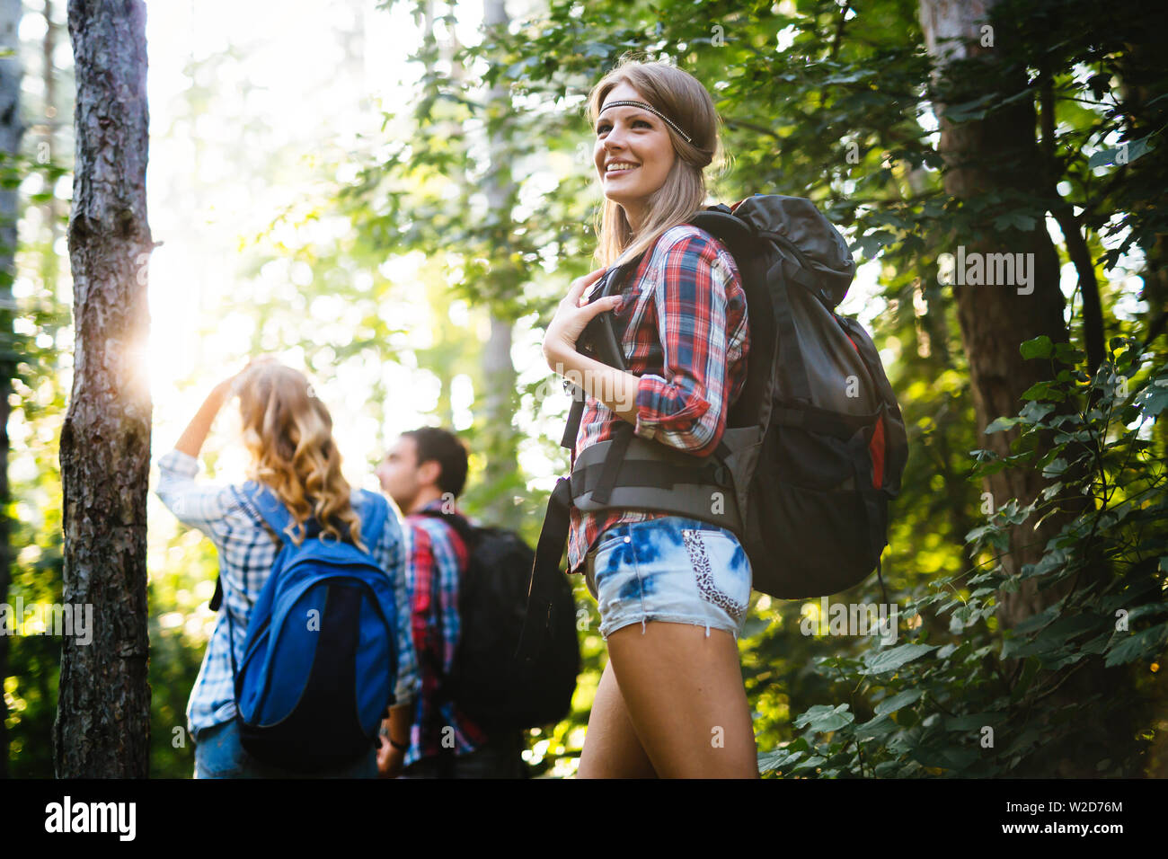 Group of backpacking hikers going for forest trekking Stock Photo - Alamy