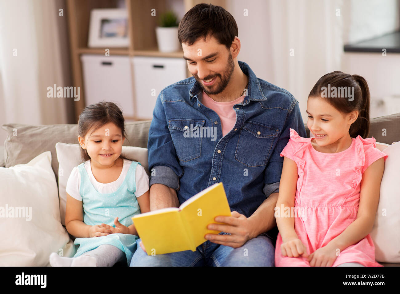 happy father with daughters reading book at home Stock Photo - Alamy
