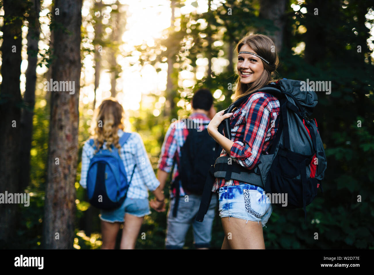 Group of backpacking hikers going for forest trekking Stock Photo - Alamy