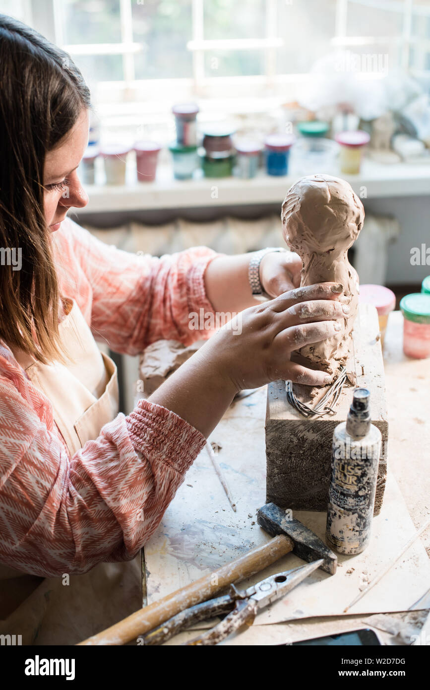 Lady sculptor working in her studio, ceramis artist's hands making ...