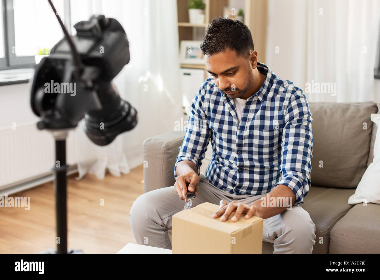 male video blogger opening parcel box at home Stock Photo - Alamy