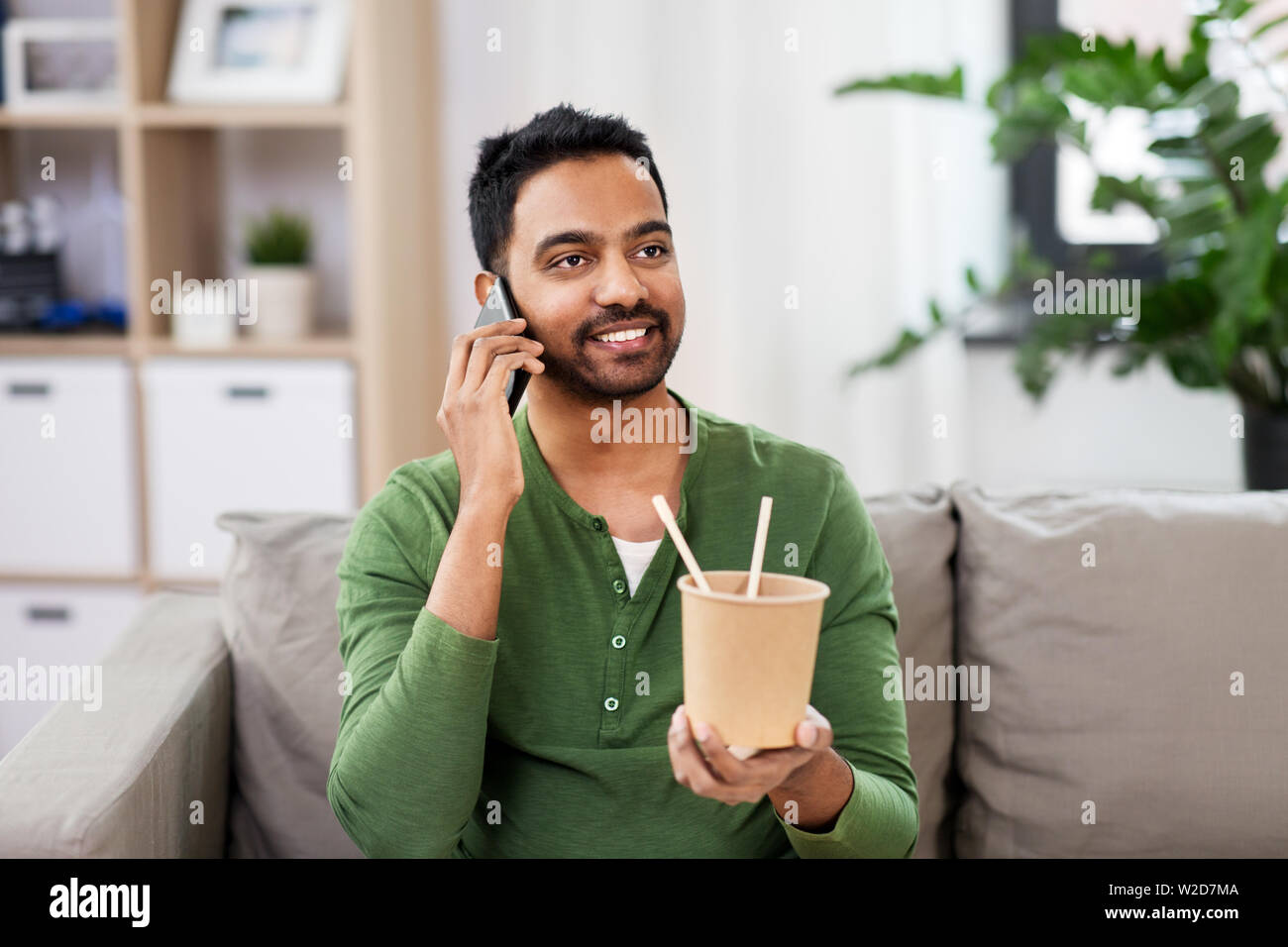 smiling indian man eating takeaway food at home Stock Photo - Alamy