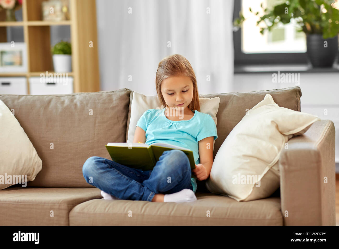 little girl reading book at home Stock Photo - Alamy