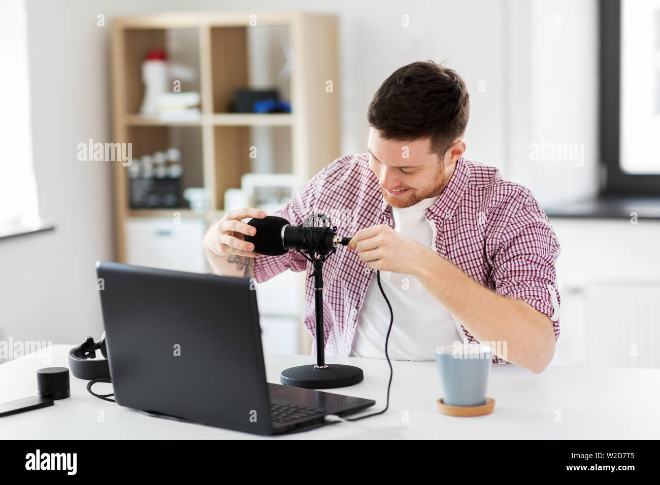 male audio blogger connecting cable to microphone Stock Photo - Alamy