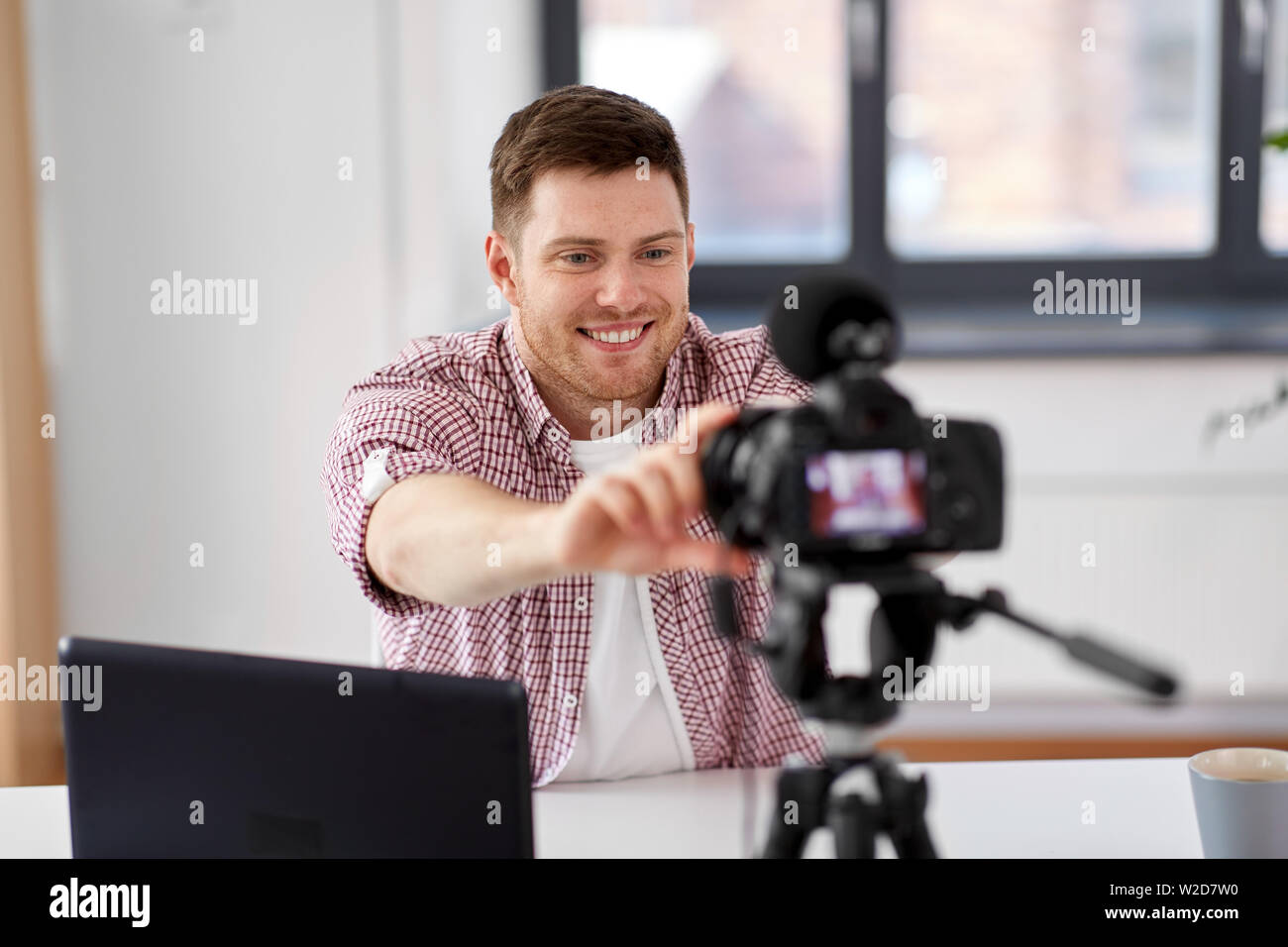 male video blogger adjusting camera at home office Stock Photo - Alamy