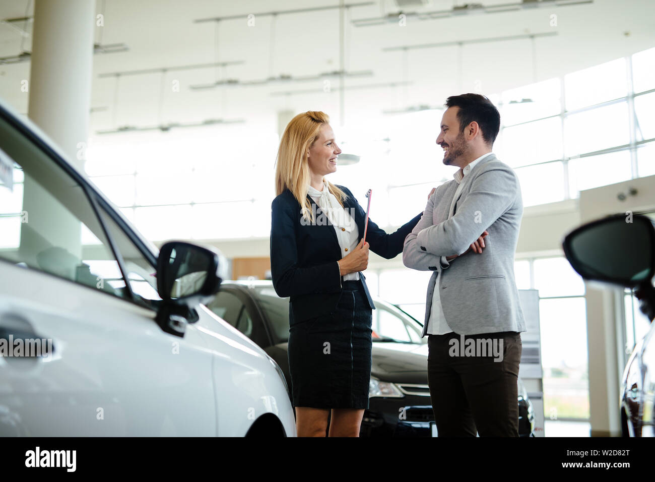 Dealer showing a new car model to the potential customer Stock Photo ...