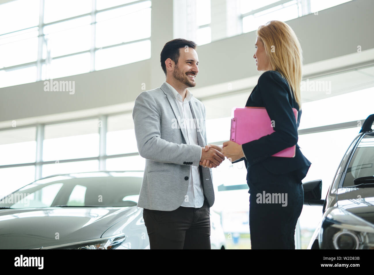 Dealer showing a new car model to the potential customer Stock Photo ...