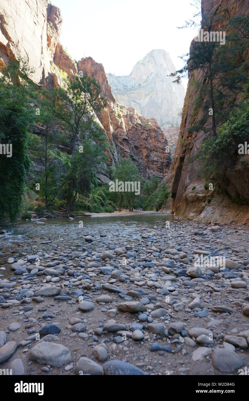 A rocky riverbed flanked by high cliffs on either side Stock Photo - Alamy