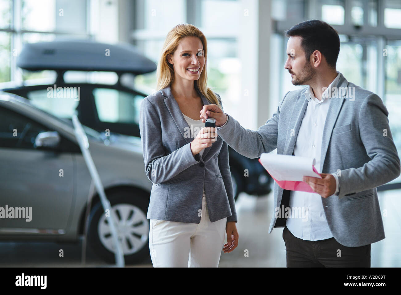 Dealer showing a new car model to the potential customer Stock Photo ...