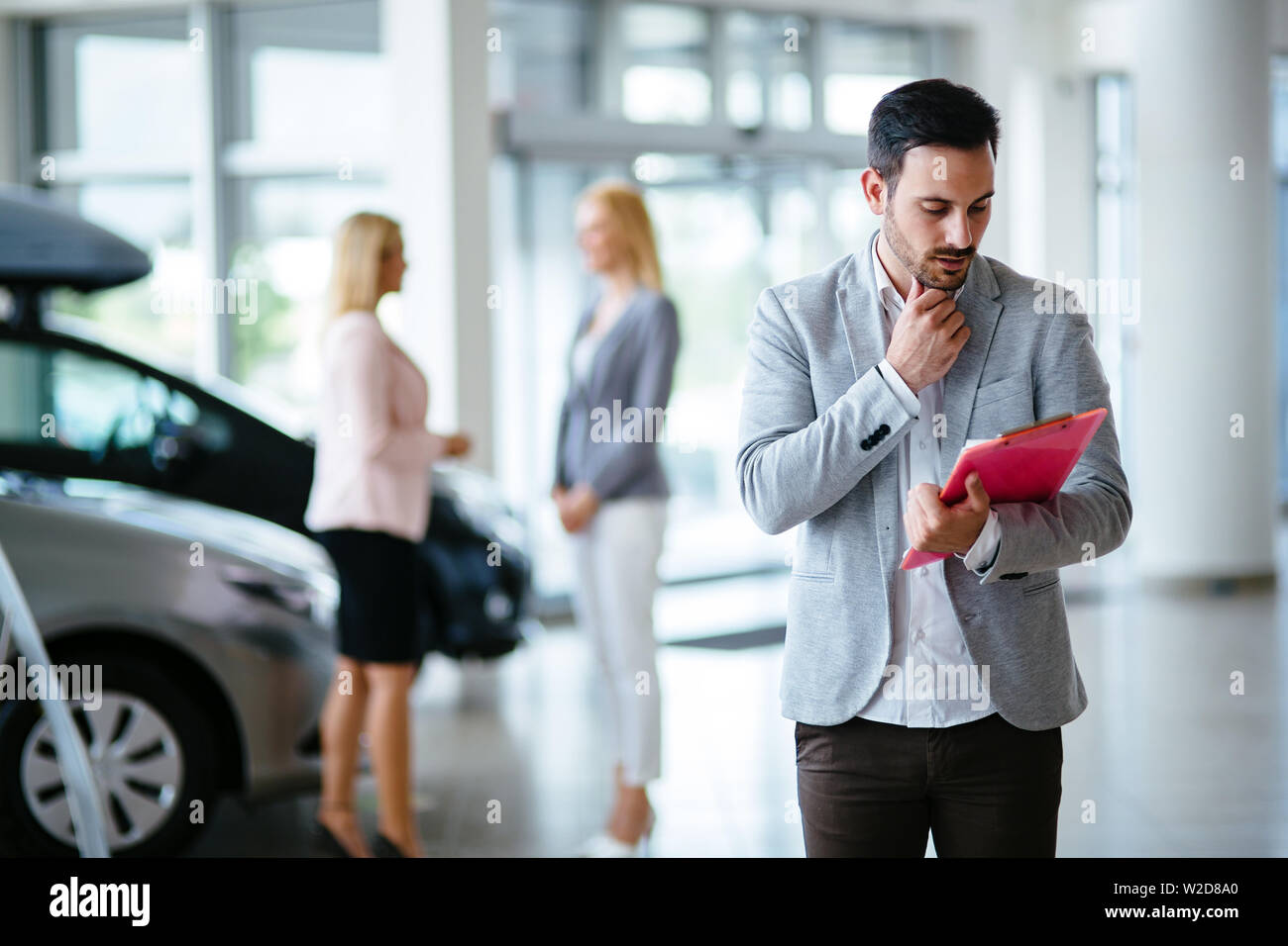 Successful businessman in a car dealership - sale of vehicles to ...