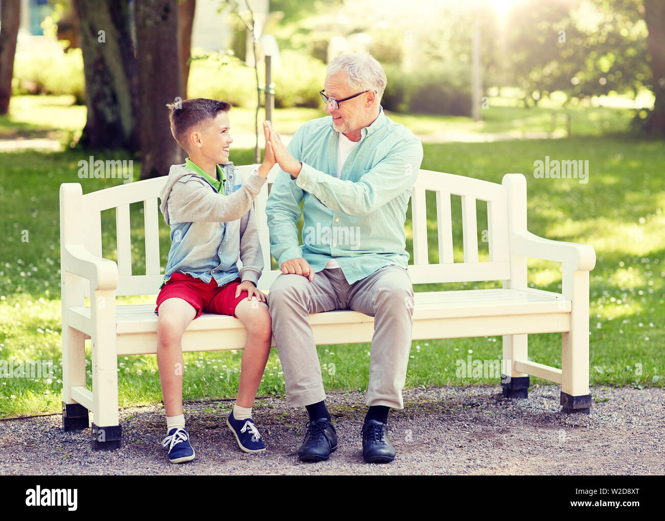 old man and boy making high five at summer park Stock Photo - Alamy