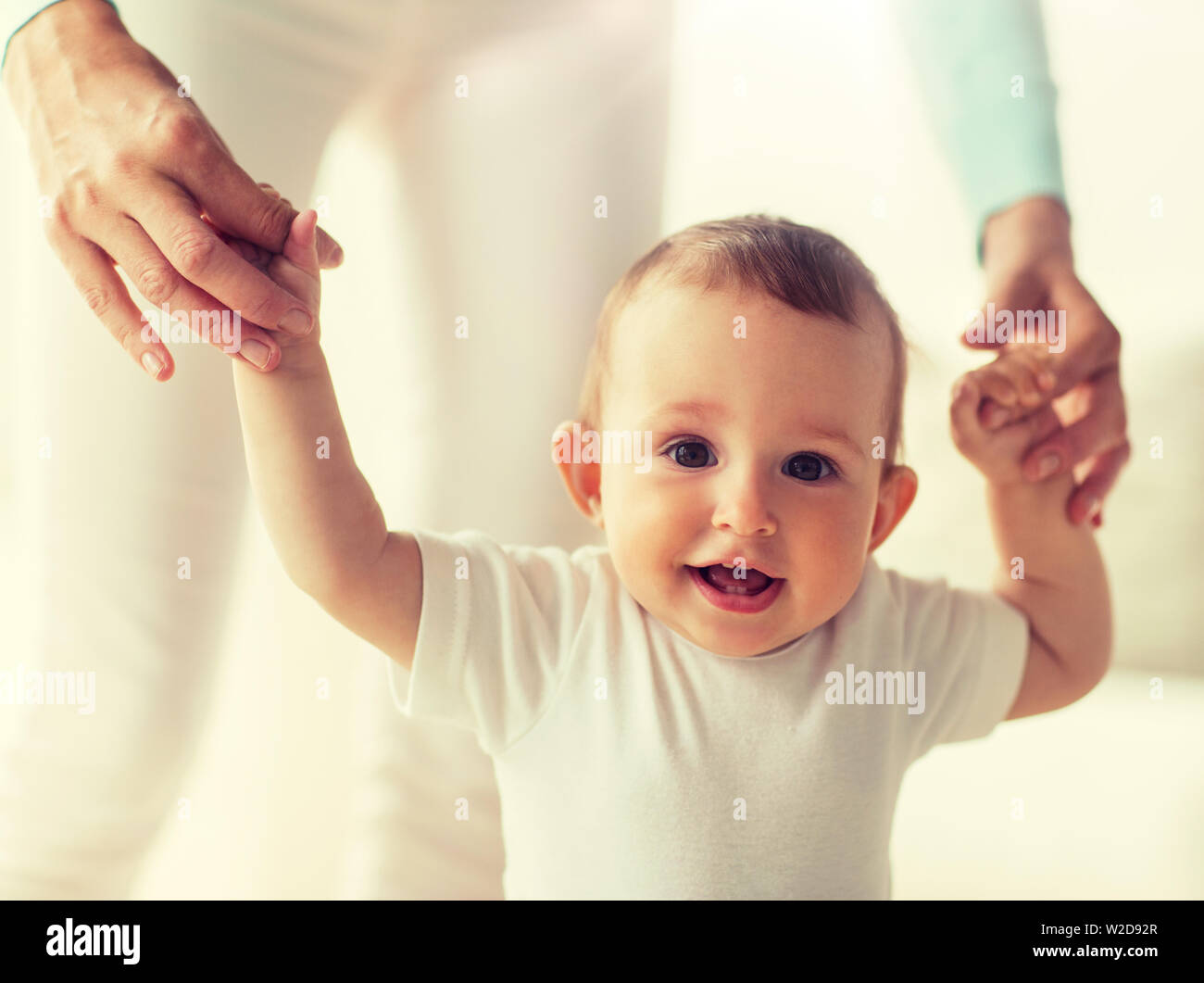 happy baby learning to walk with mother help Stock Photo - Alamy